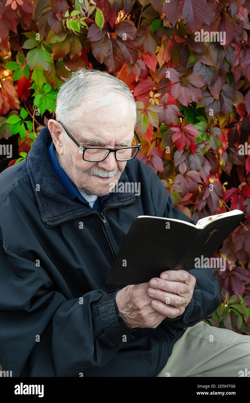 Healthy looking old man is his late 70s sitting in garden at home and ...