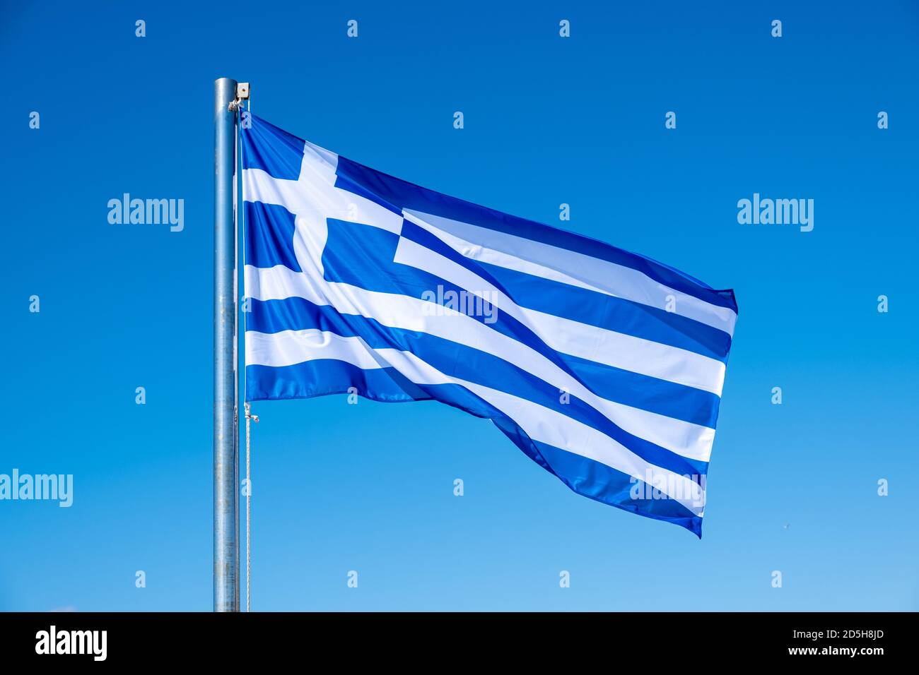 Greece sign symbol. Greek flag on flagpole waving in the wind. Blue sky ...