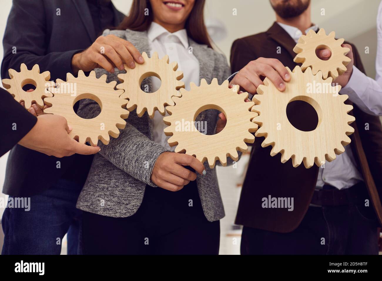 Company employees joining cogwheels as metaphor for effective business ...