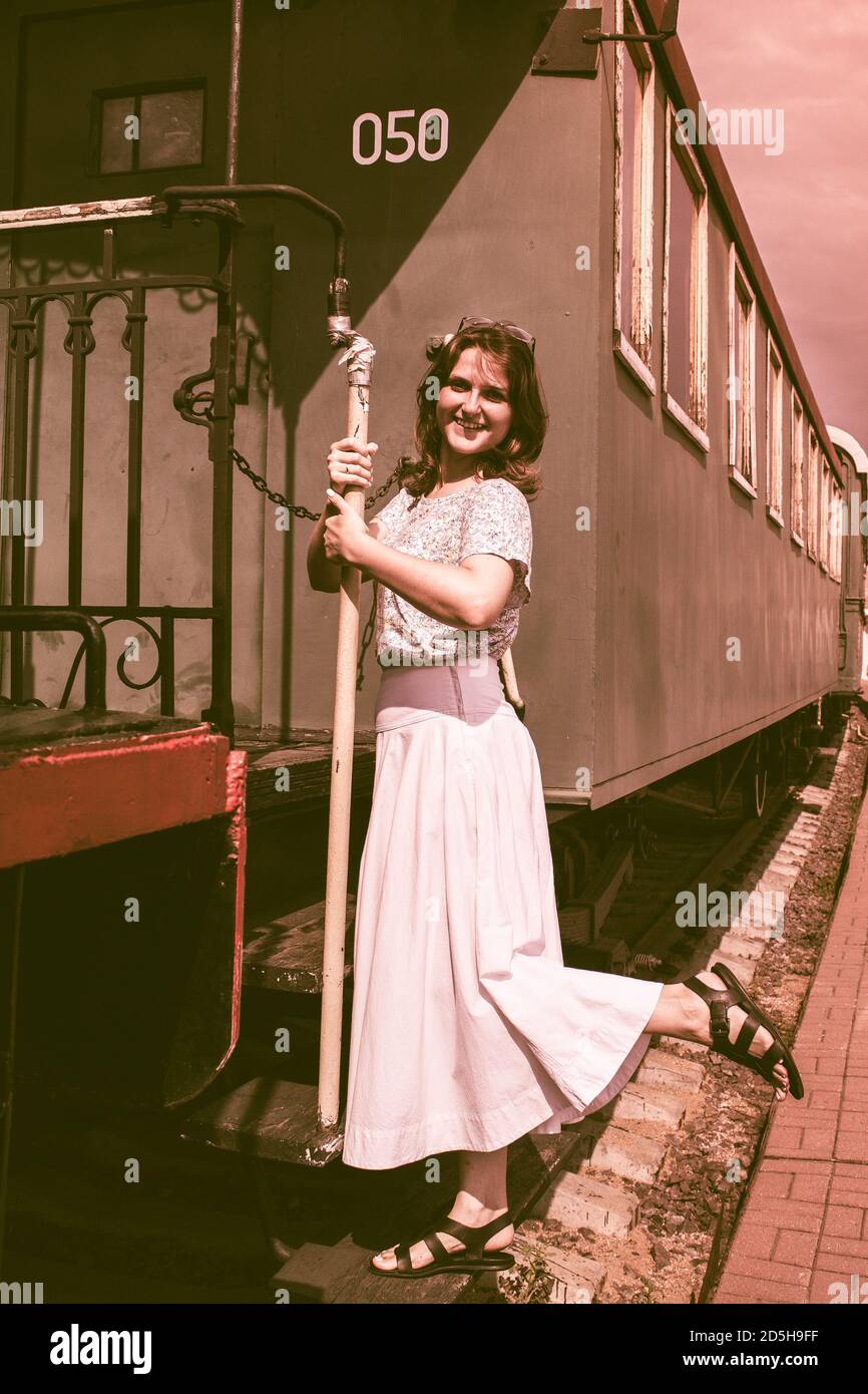 Woman stands on the steps of the cars train. The vintage train is at ...