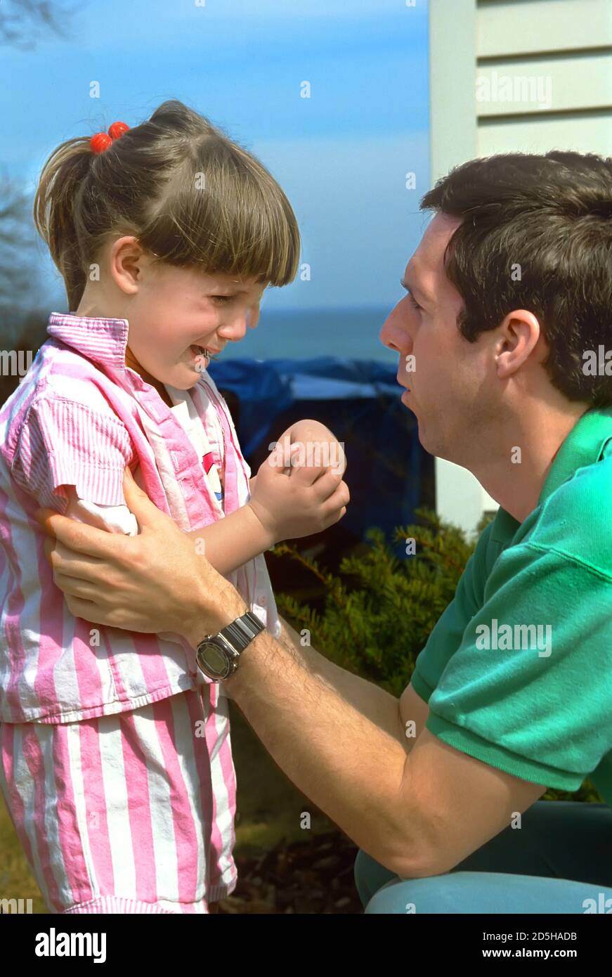 Father tries to console a crying young daughter Stock Photo - Alamy