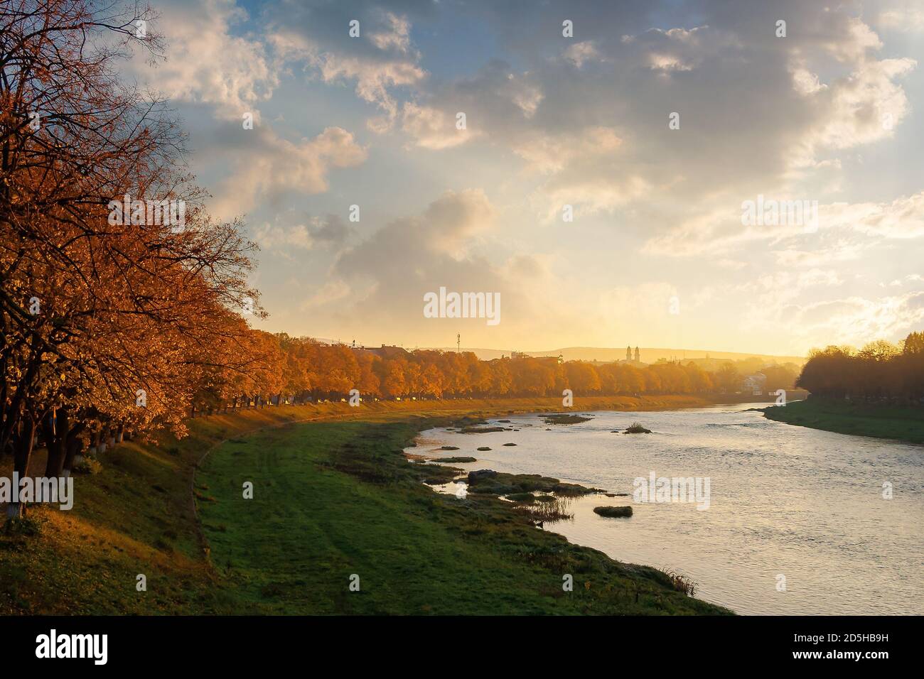 river uzh at sunrise. beautiful cityscape autumn scenery. linden alley ...