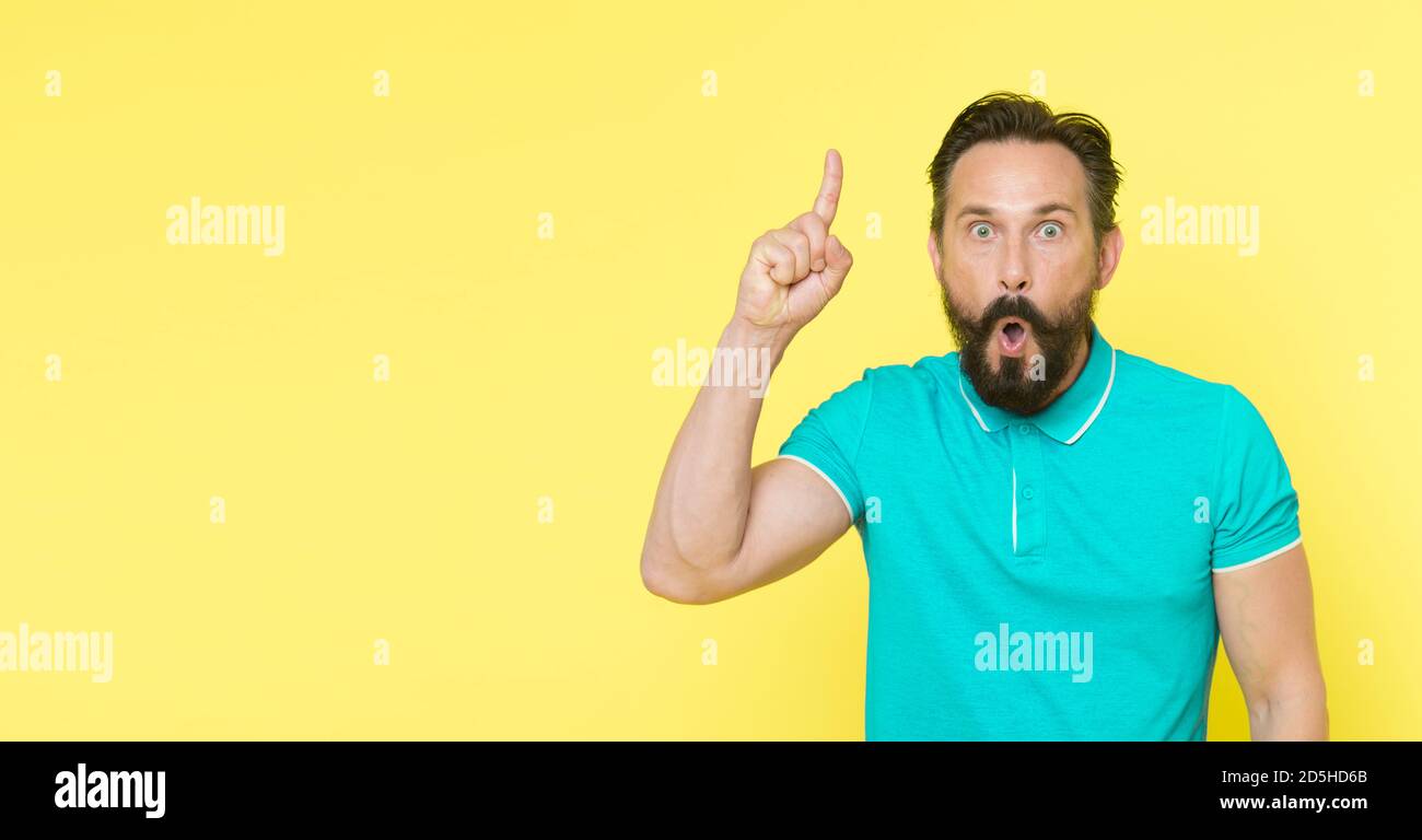 Surprised man with open mouth keep finger pointing up. Beraded man ...