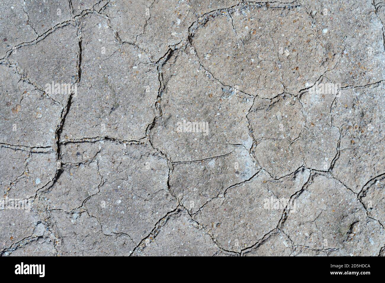 Gray dry cracked surface of volcanic ground turned into desert. Natural ...