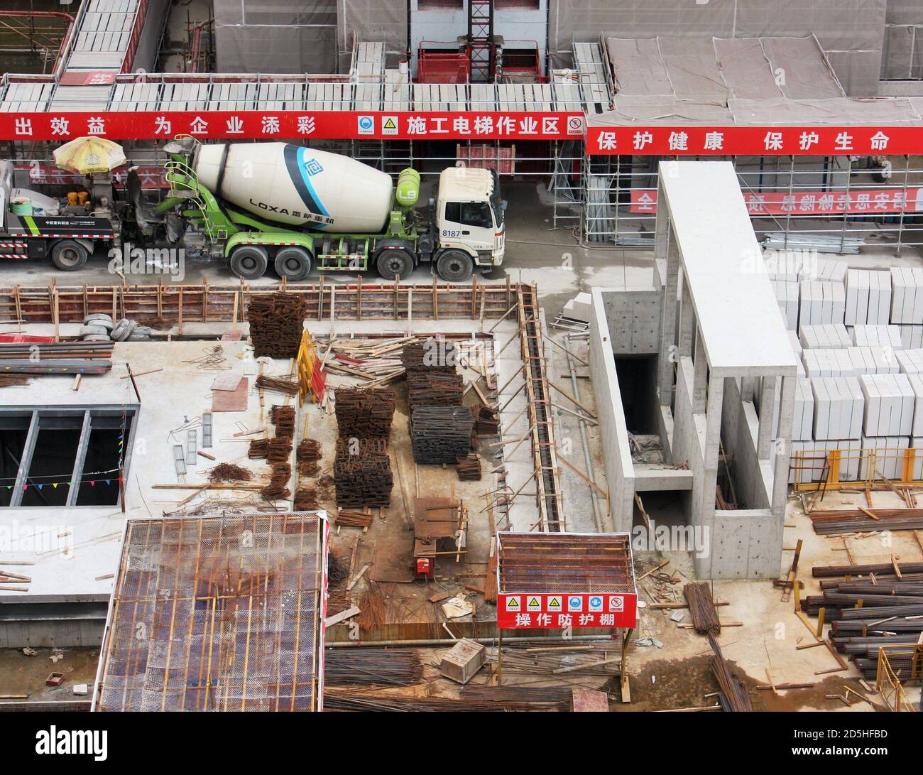 Urban construction site with cement mixers, concrete, scaffolding ...