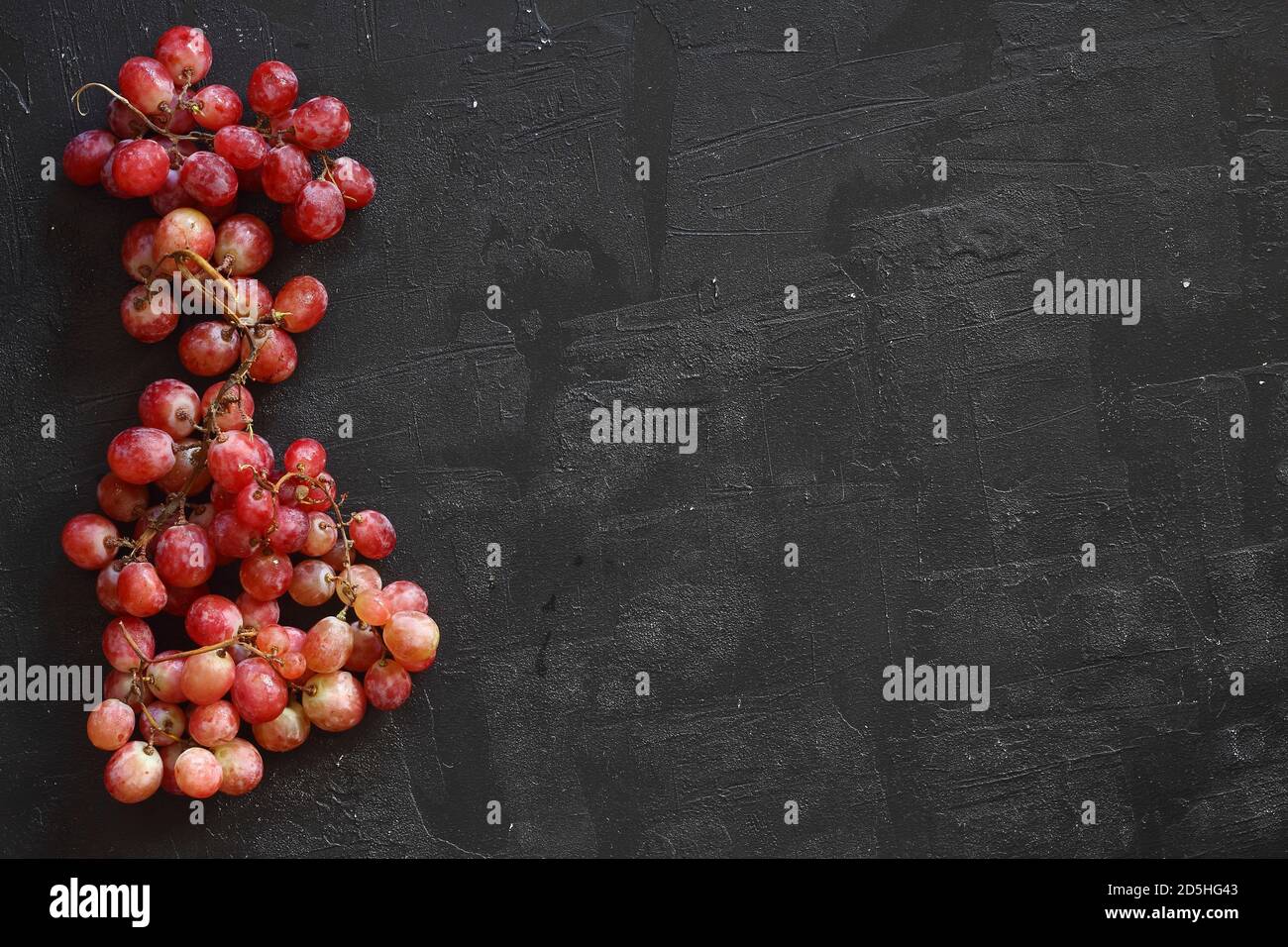 Bunch of fresh ripe juicy red grape flat lay on white background, copy ...