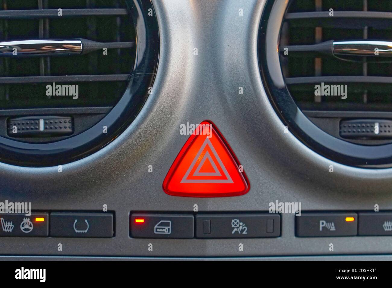 Illuminated red hazard safety triangle button in car Stock Photo - Alamy