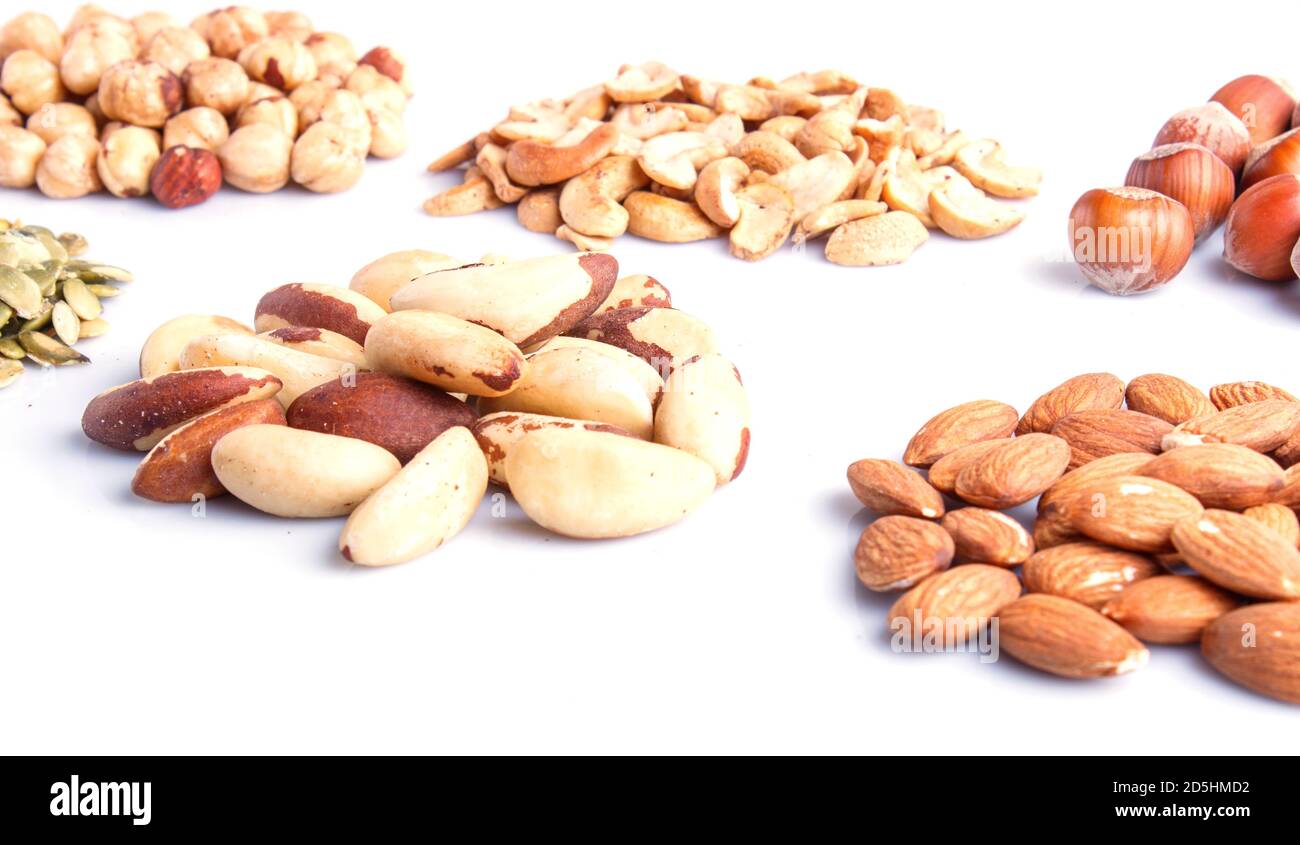 Piles of various nuts and seeds isolated on white background. hazelnut ...