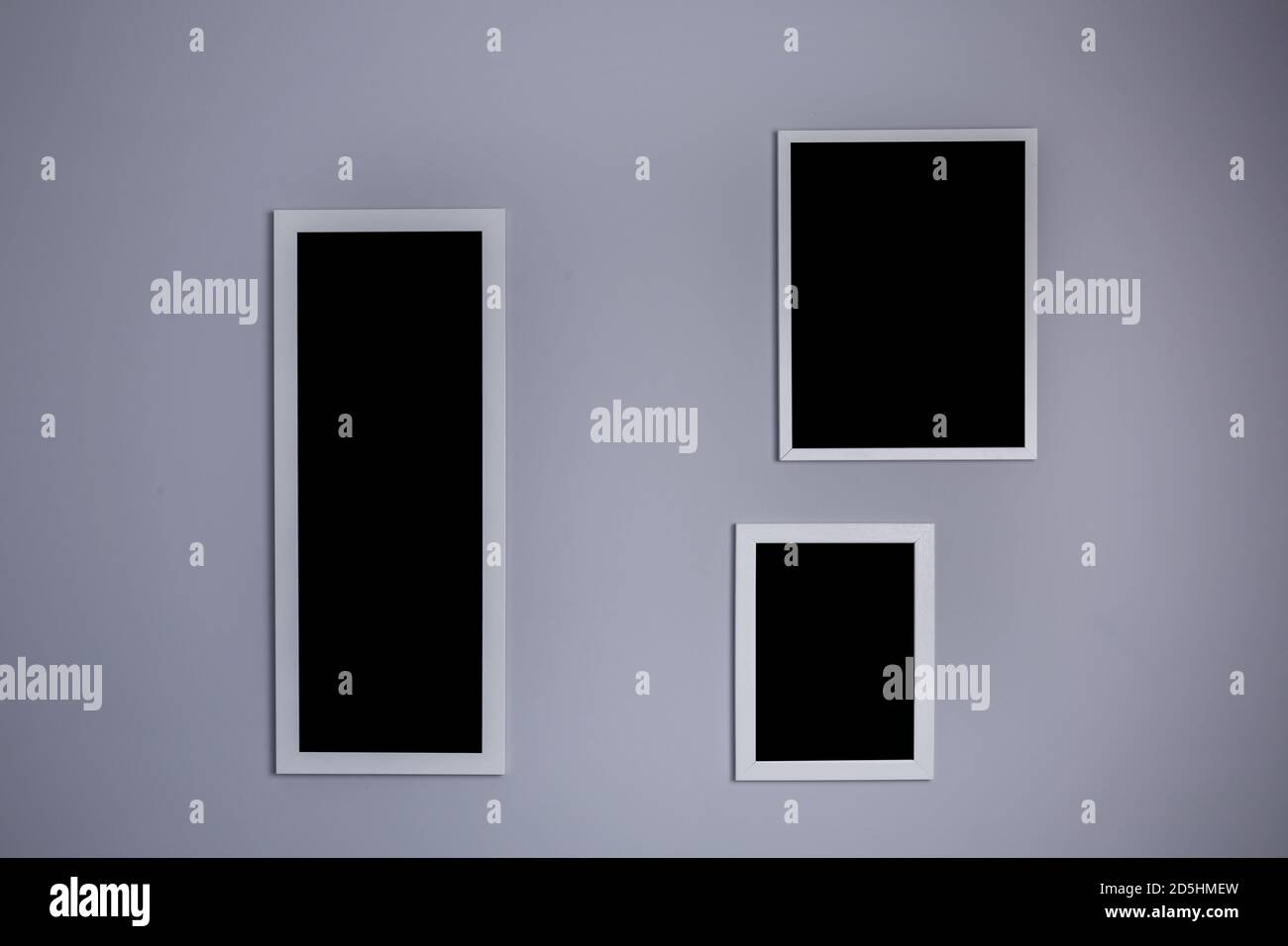 Poster mockup with three frames on empty grey wall Stock Photo - Alamy