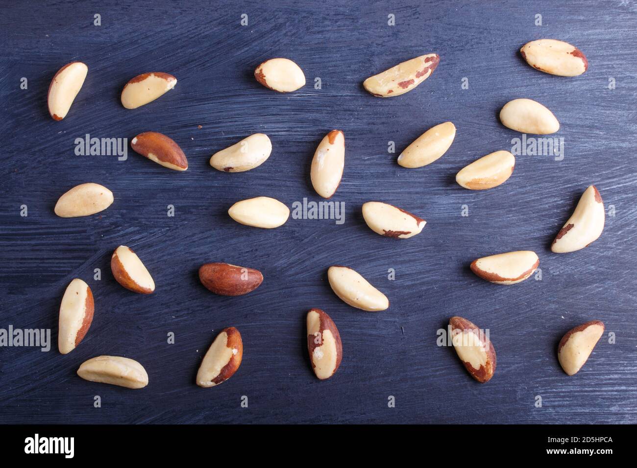 Pattern and texture made from Brazil nuts on black wooden background ...