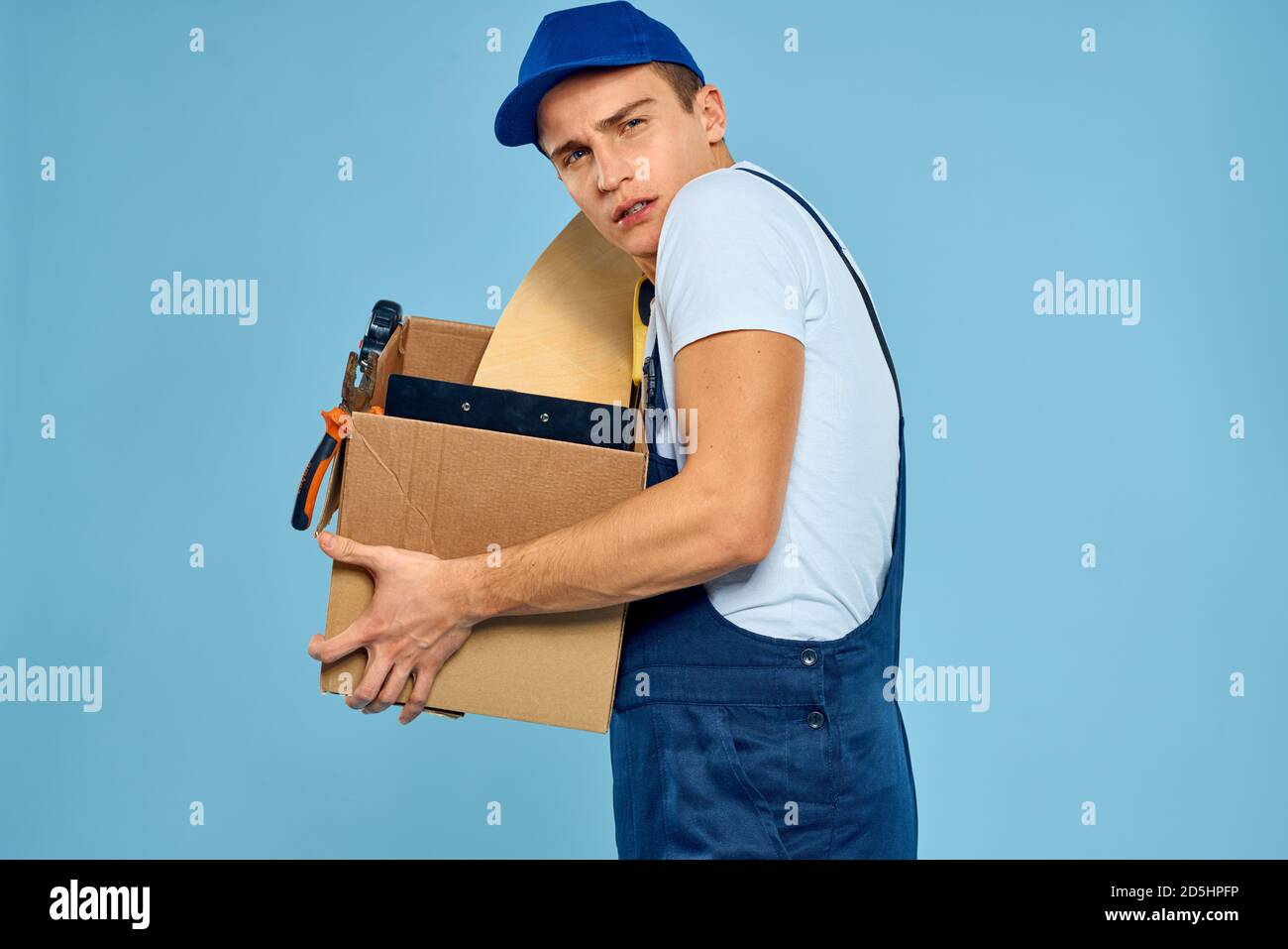 working man in uniform box with tools loader delivery blue background ...