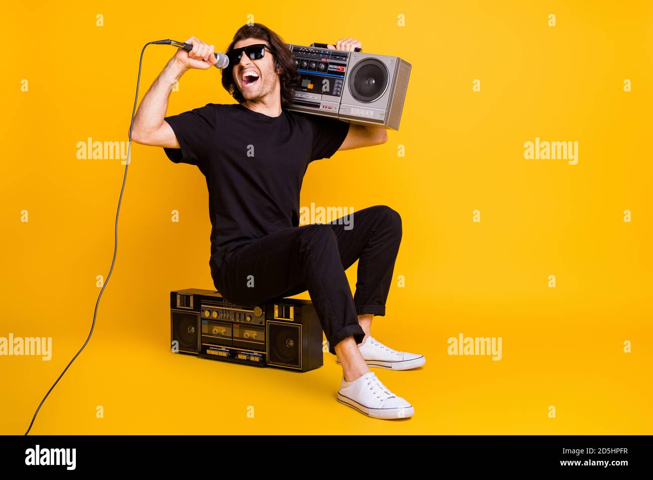 Full length photo of young man hold mic open mouth vintage radio sit ...