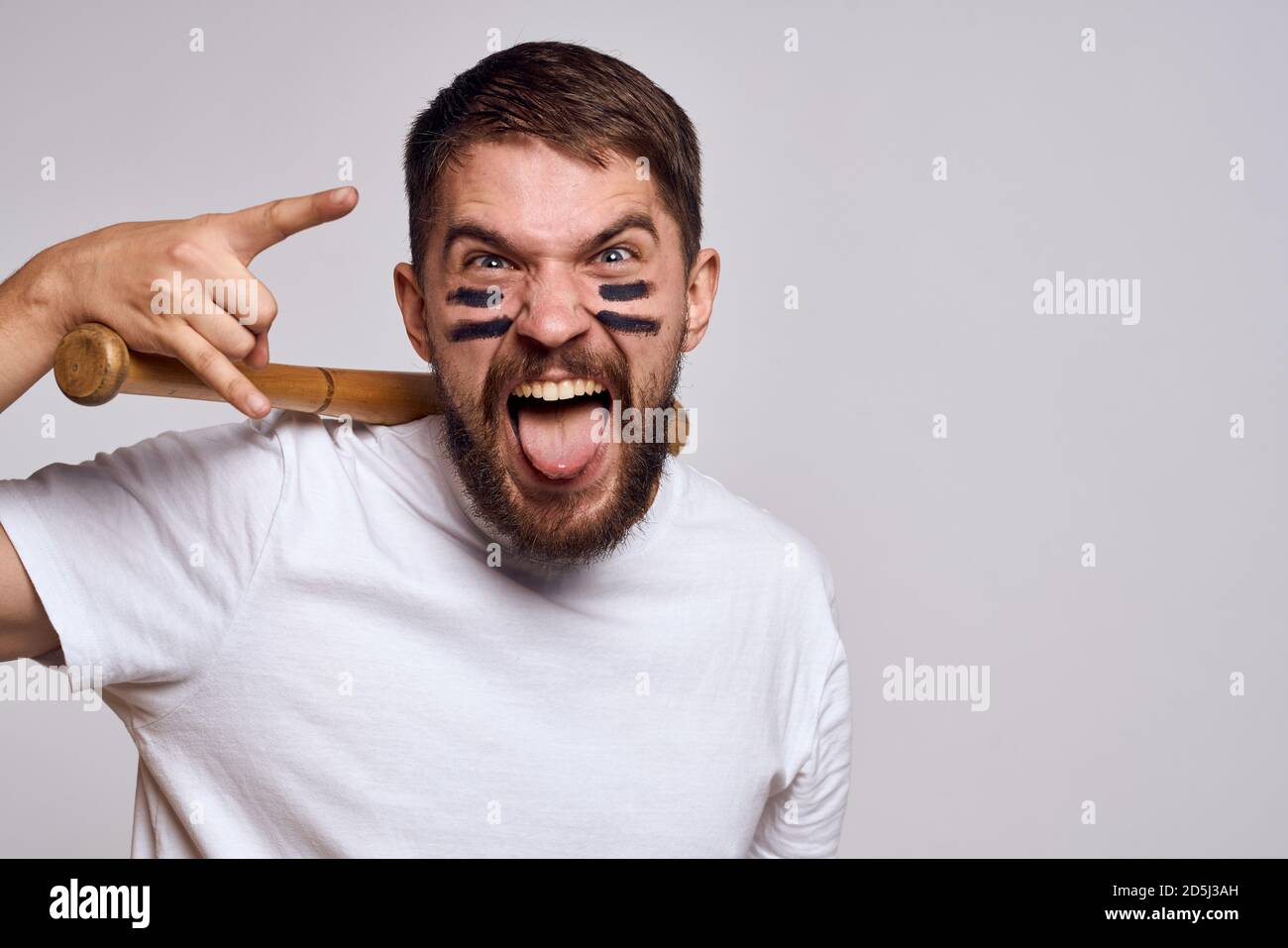 Energetic man holding a bat behind his head and emotions light ...