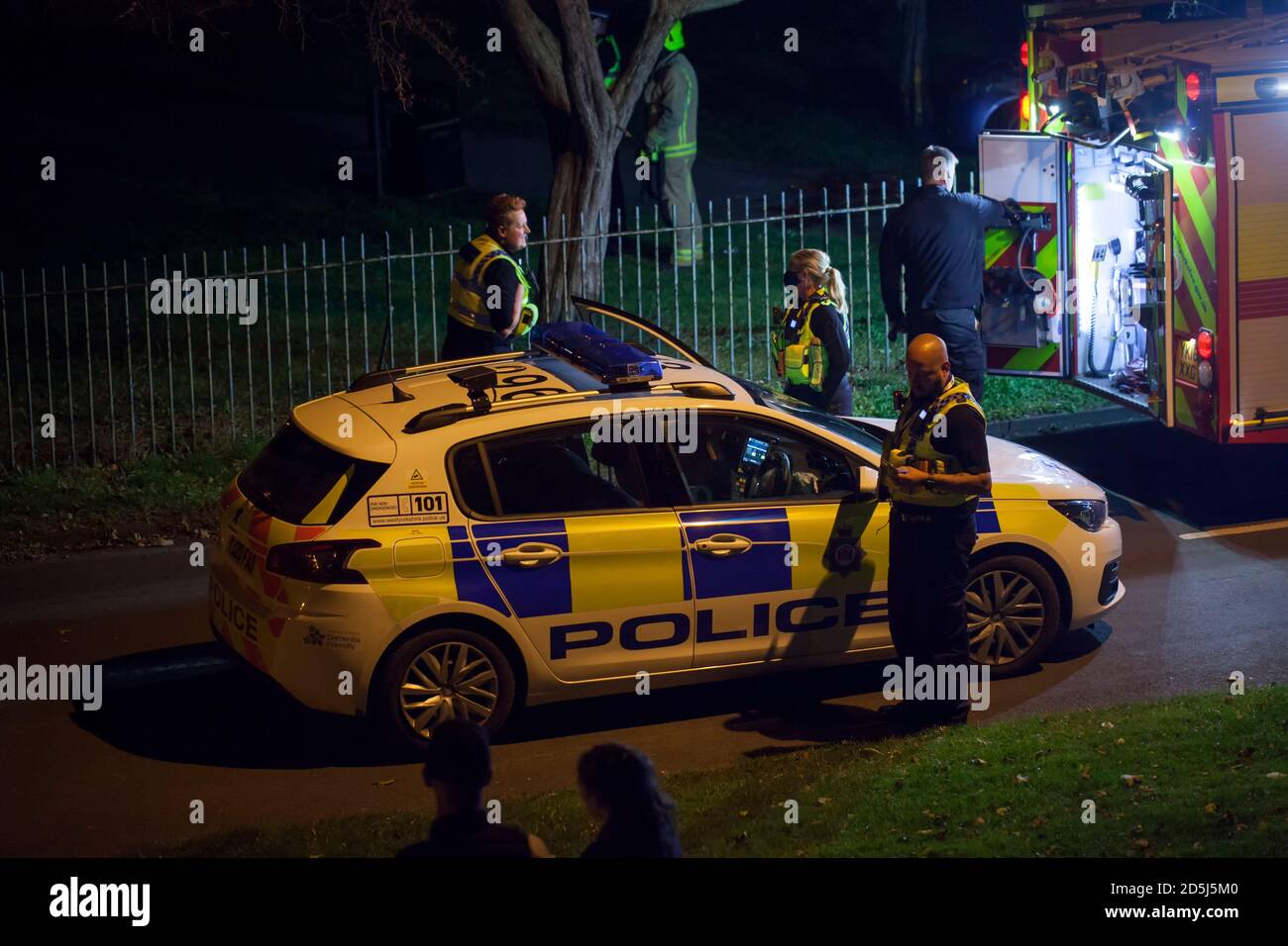 Police and fire brigade responding at the scene of a car fire in an ...