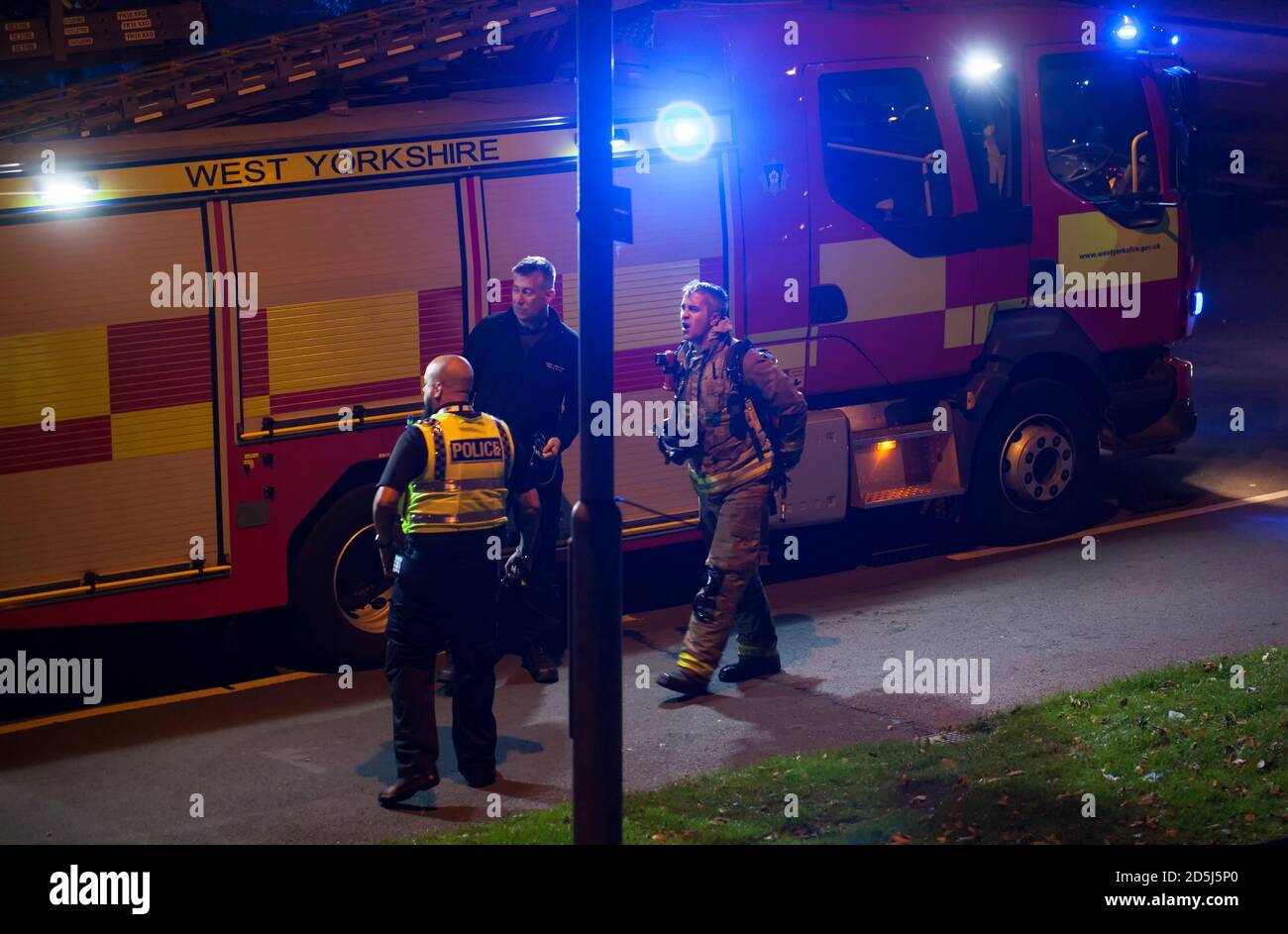 UK police officer liasing with the fire brigade at a emergency scene.A ...