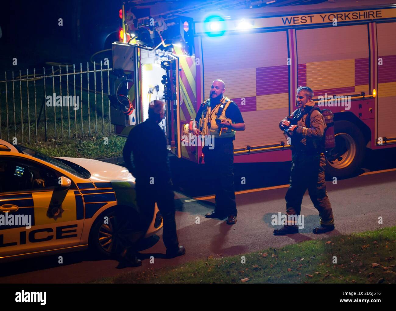 UK police officer liasing with the fire brigade at a emergency scene.A ...