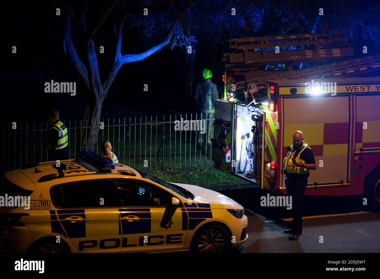 Police and fire brigade responding at the scene of a car fire in an ...