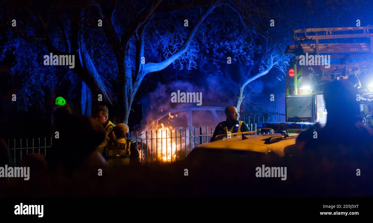 Police and fire brigade responding at the scene of a car fire in an ...