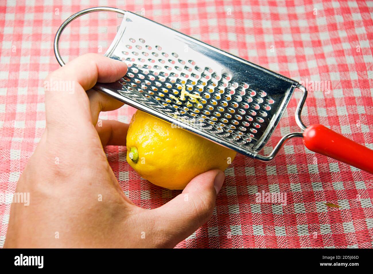 Person grating a fresh whole lemon Stock Photo - Alamy