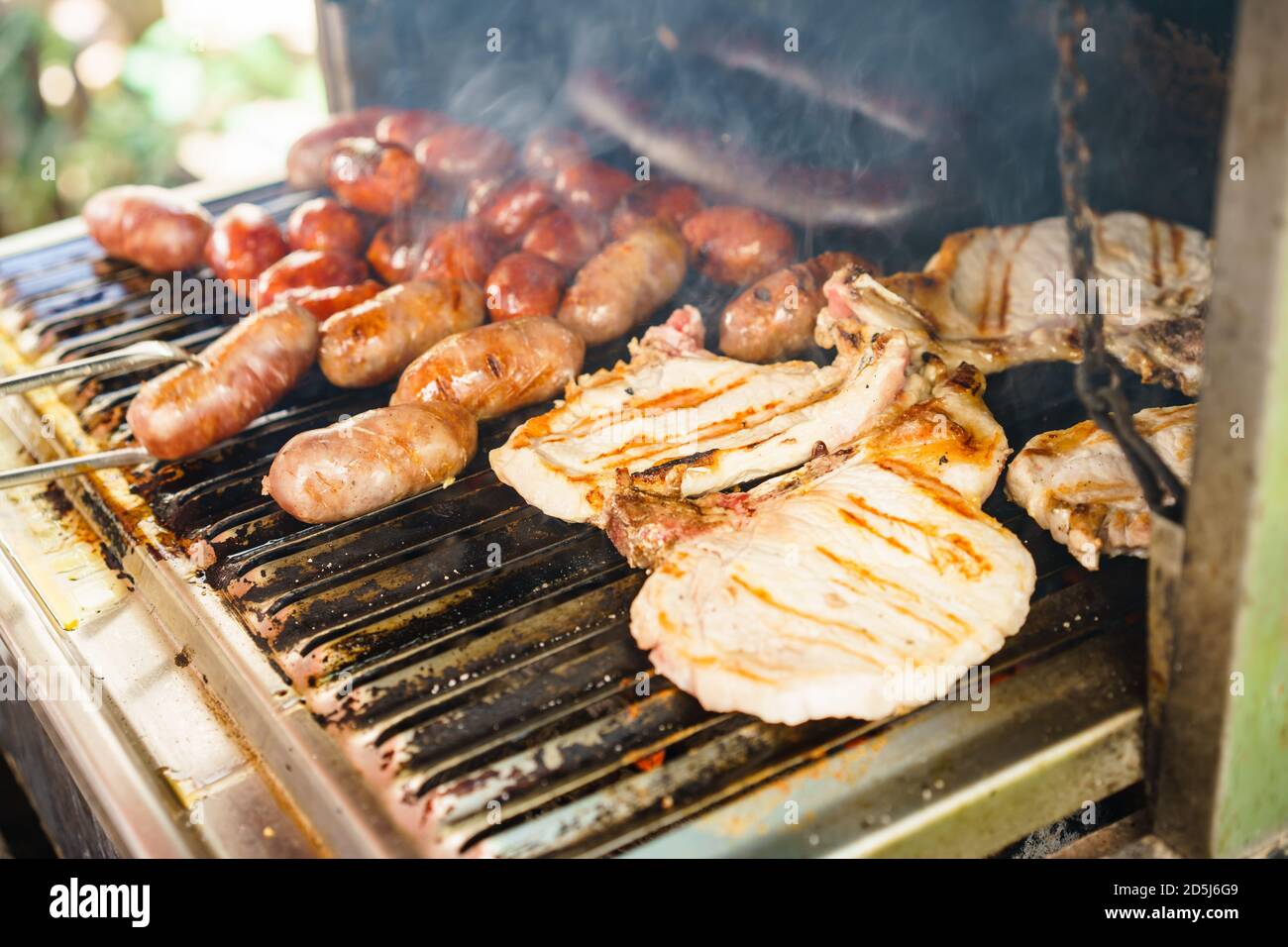 High angle shot of sausages and meat on a grill Stock Photo - Alamy