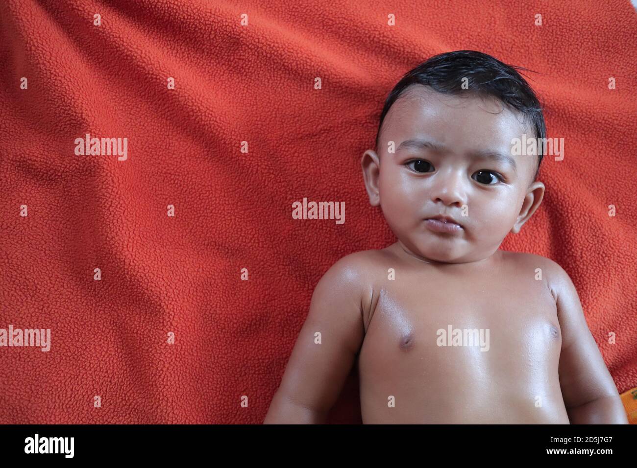 An overhead shot of a cute Indian child lying on the bed Stock Photo ...