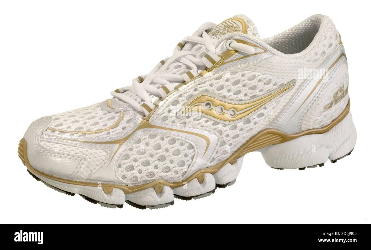 gold and white women's running shoe with white laces photographed on a ...