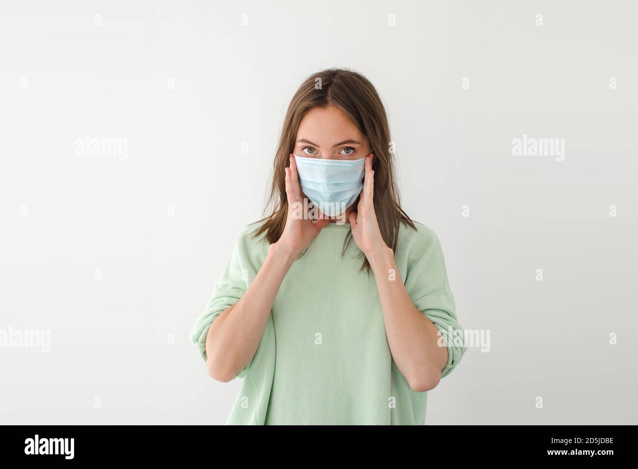 Adult woman touching medical mask Stock Photo - Alamy