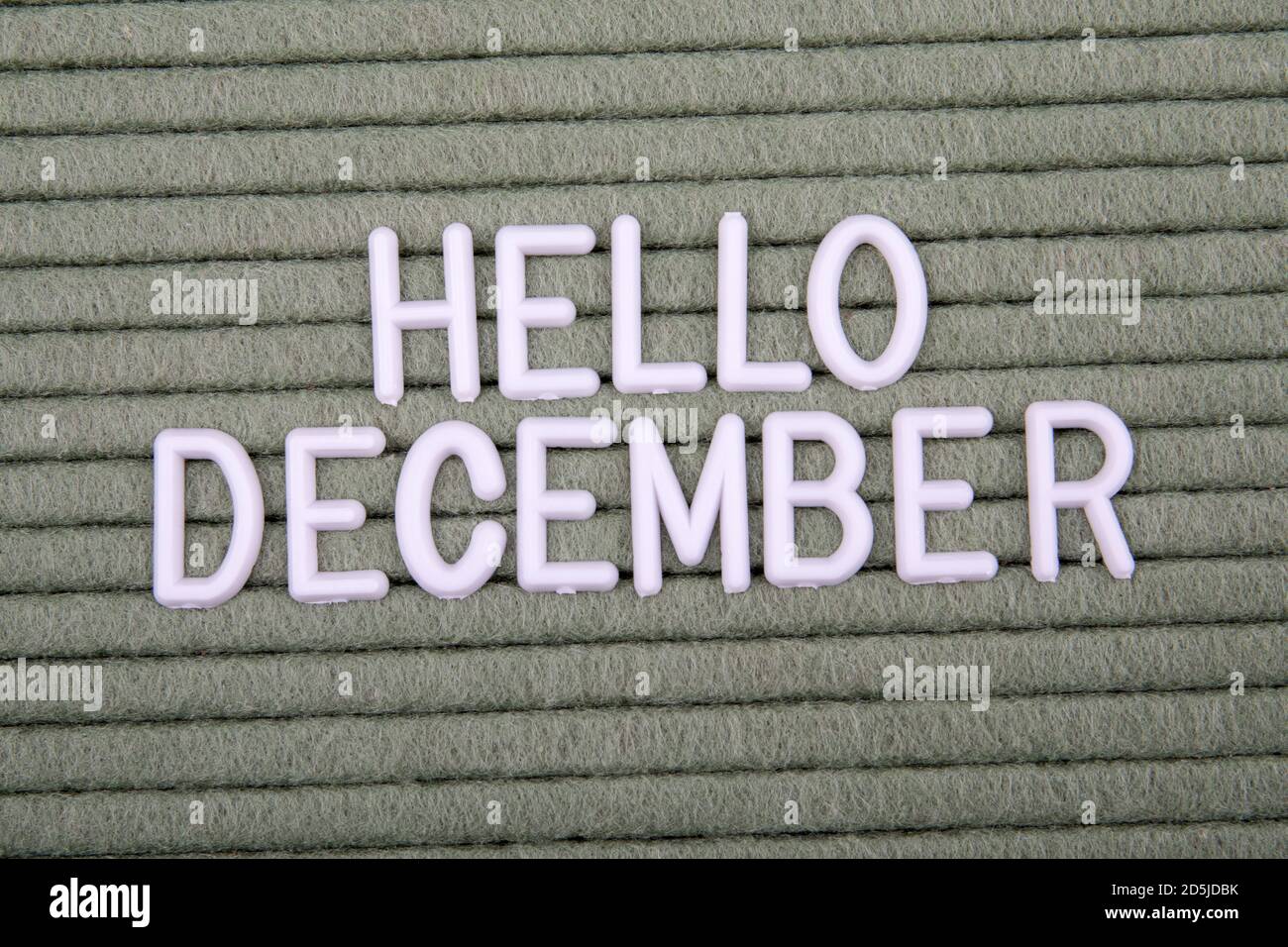 HELLO DECEMBER. White letters of the alphabet on a green background ...