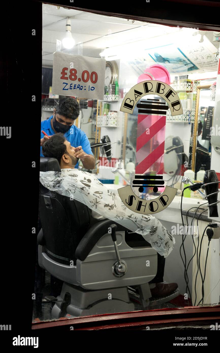 A barber shop in Whitechapel. The staff wearing face mask due to ...