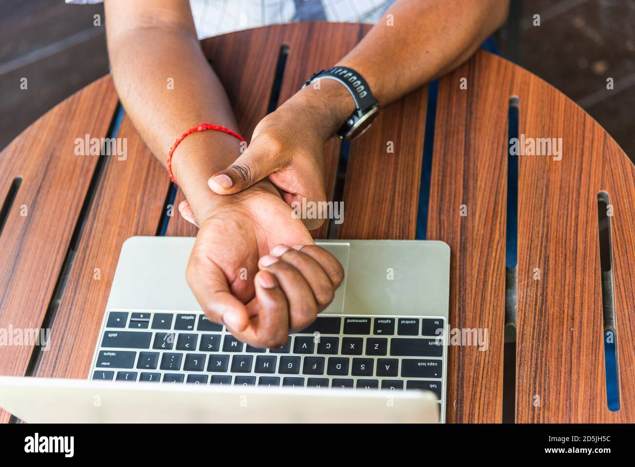 Closeup hands the Asian black man holding his wrist pain from using ...
