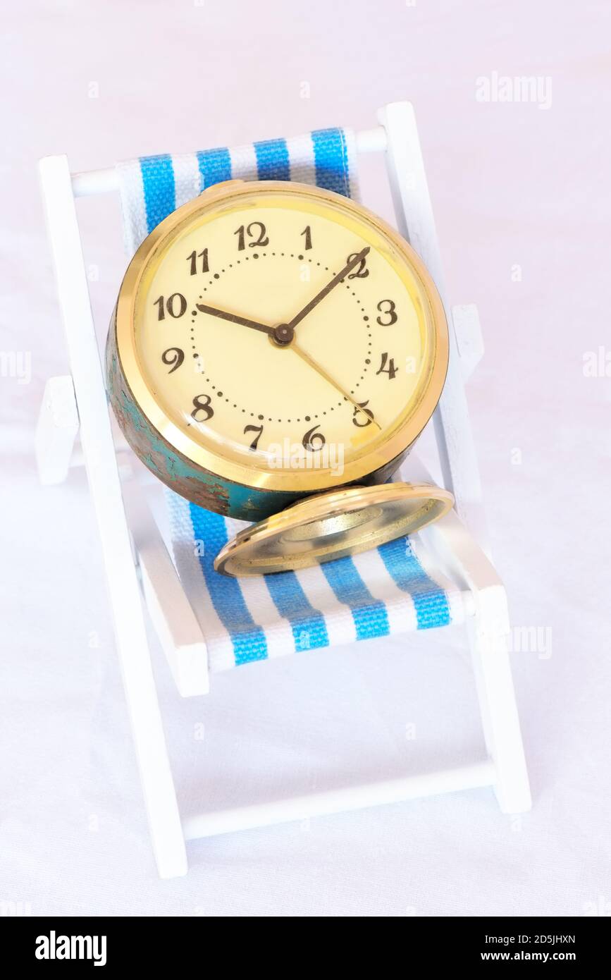 Vintage clock on a lawn chair, leisure time concept Stock Photo - Alamy