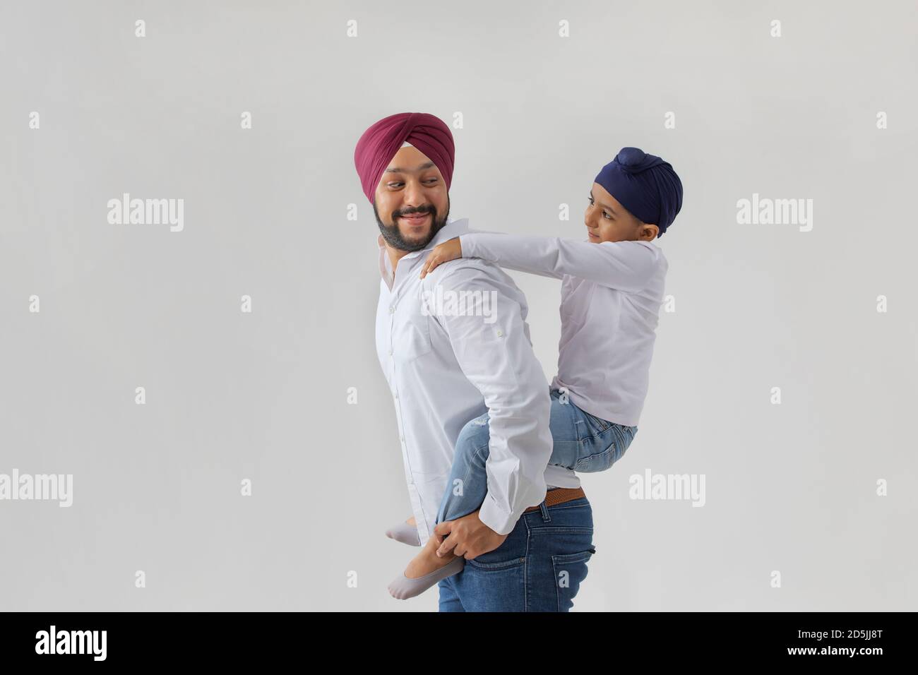 A SIKH FATHER CARRYING SON ON BACK AND LOOKING AT HIM Stock Photo - Alamy