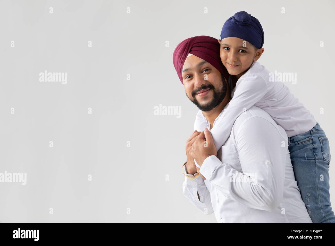 A SIKH FATHER AND SON HAPPILY STANDING TOGETHER AND LOOKING AT CAMERA ...