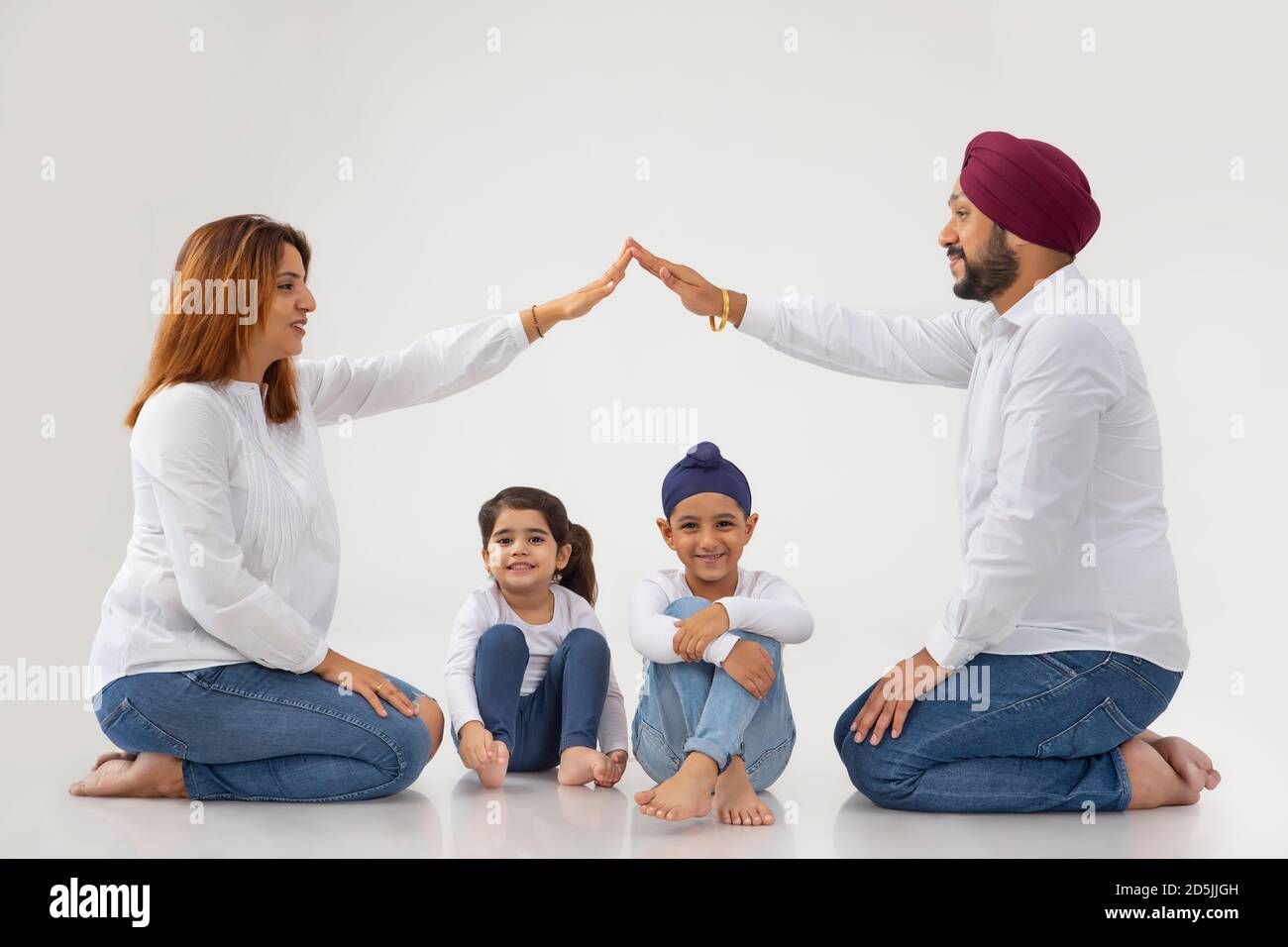 SIKH FATHER AND MOTHER SITTING DOWN AND FORMING SHELTER WITH HANDS WITH ...