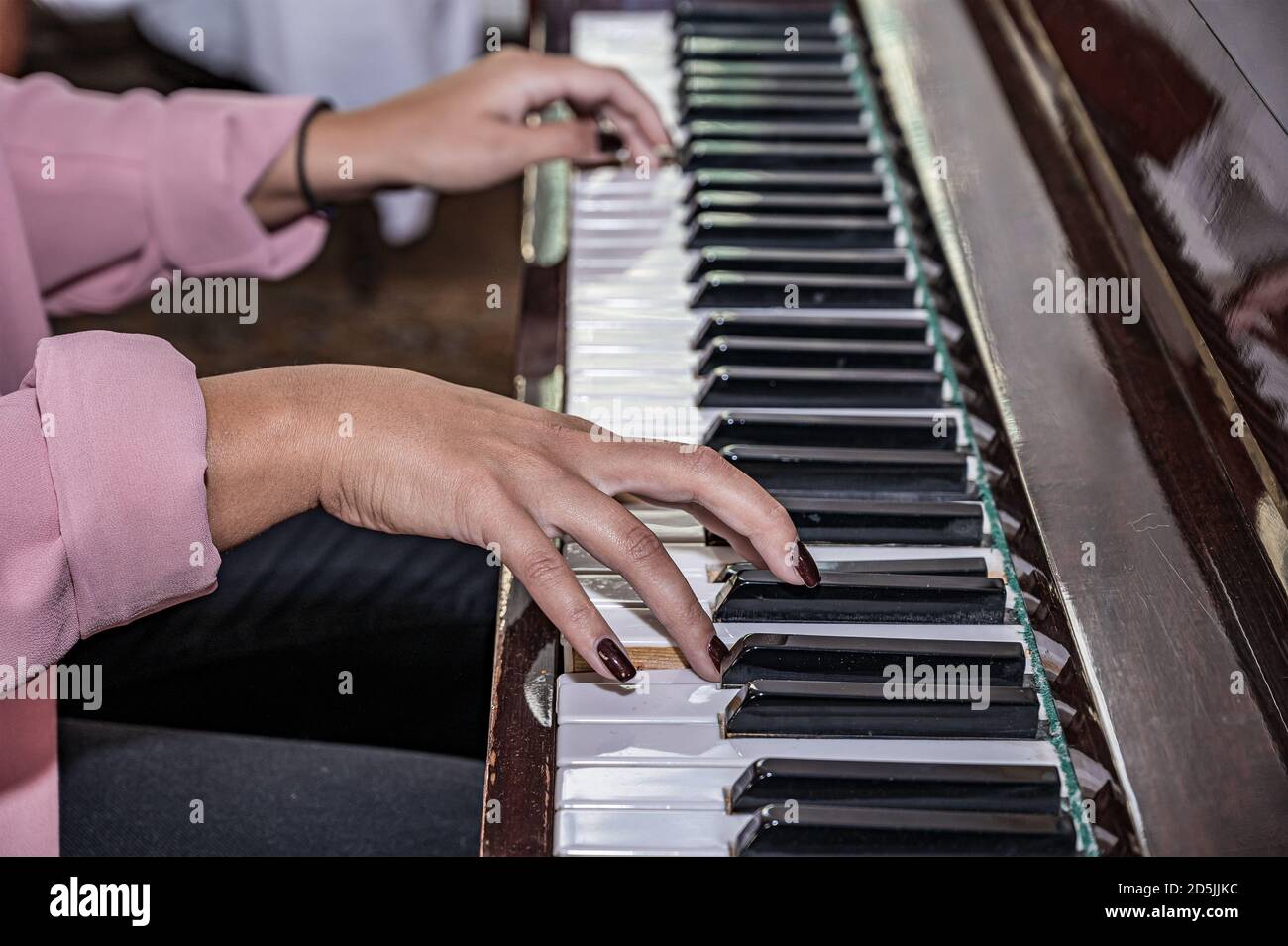 The pianist's hands are playing the piano. the arms are bent over the ...