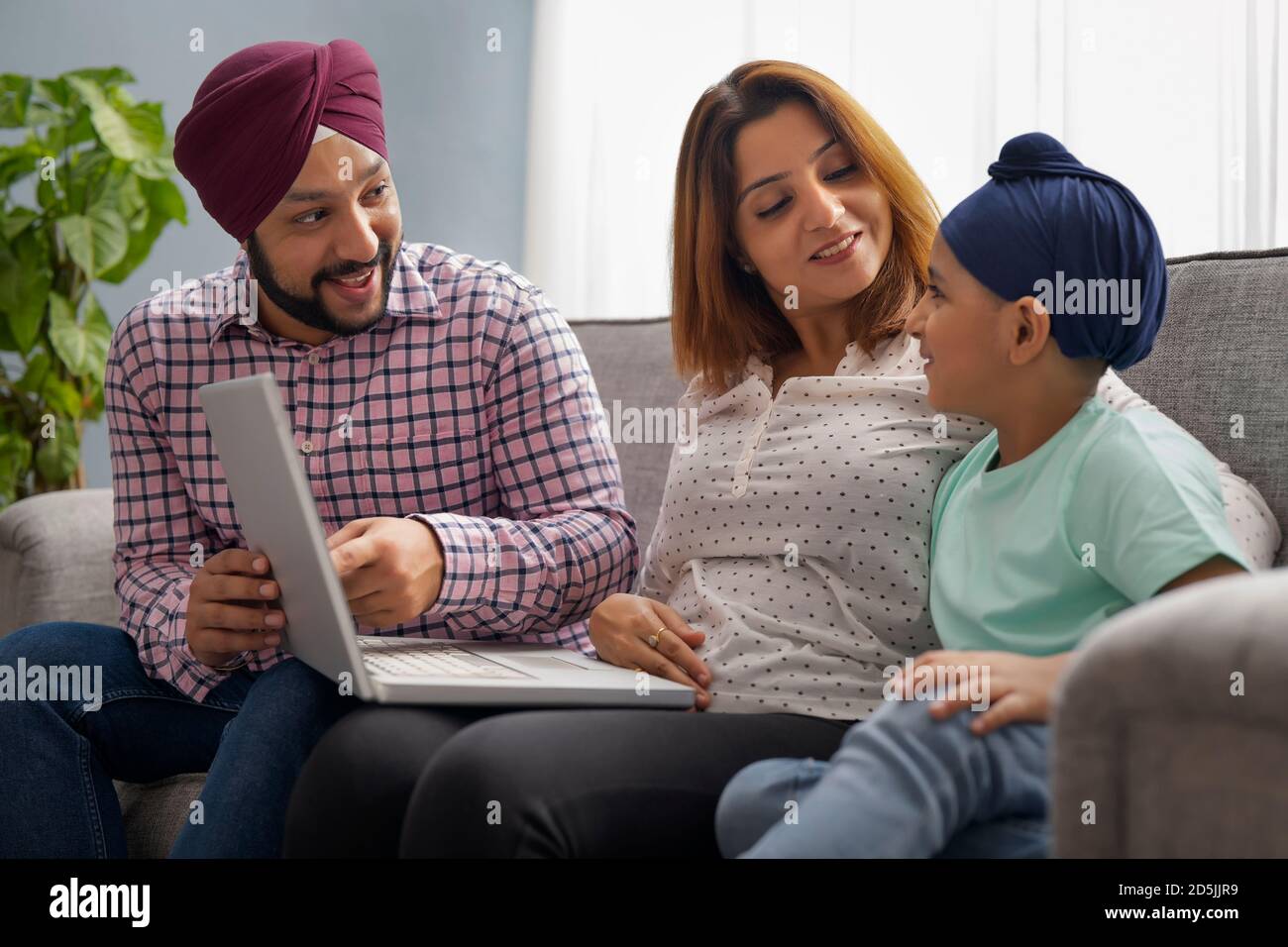 A SIKH FATHER AND MOTHER TEACHING SON USING A LAPTOP Stock Photo - Alamy