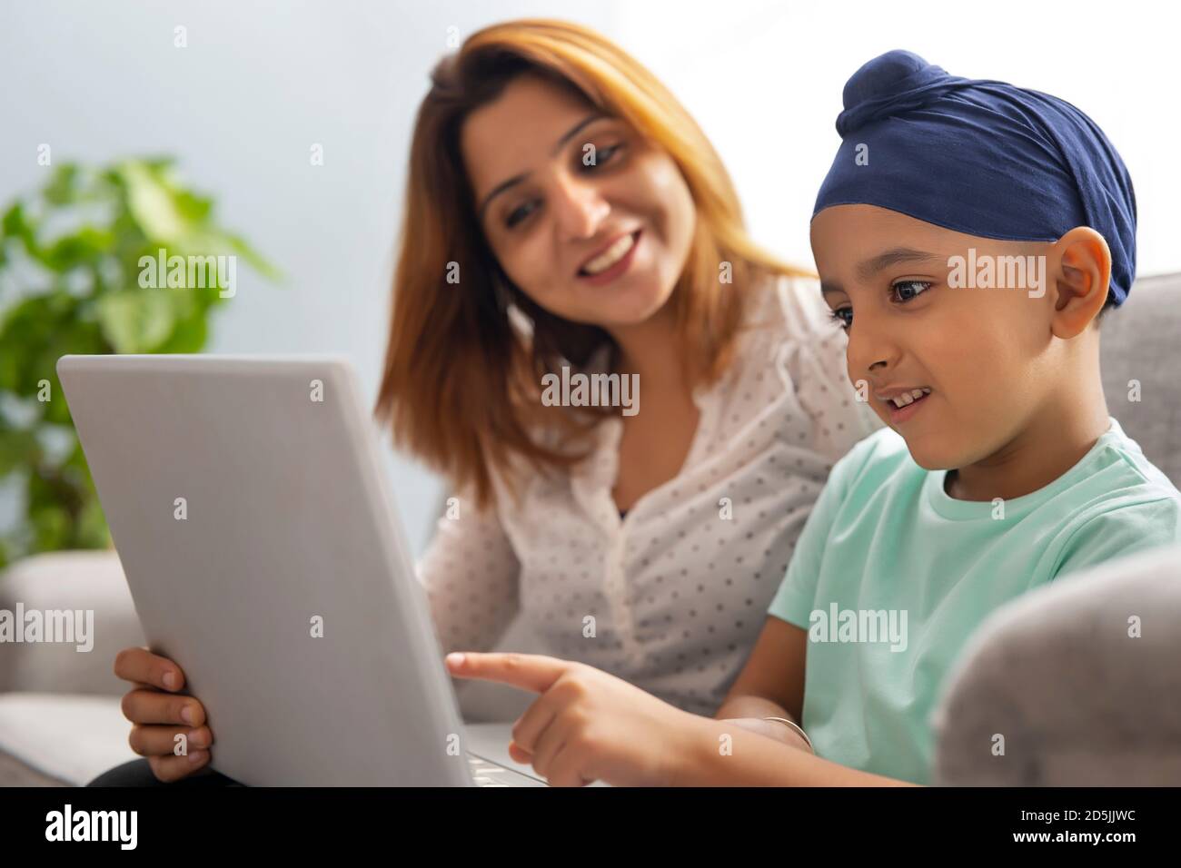 A SIKH BOY STUDYING WITH MOTHER ON A LAPTOP Stock Photo - Alamy