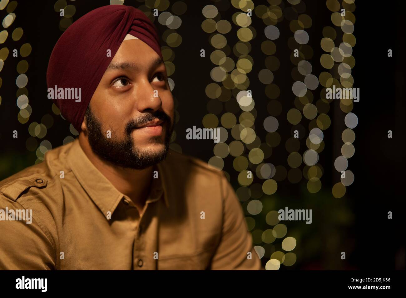 A SIKH MAN LOOKING ABOVE AND POSING WITH LIGHTS IN BACKGROUND Stock ...