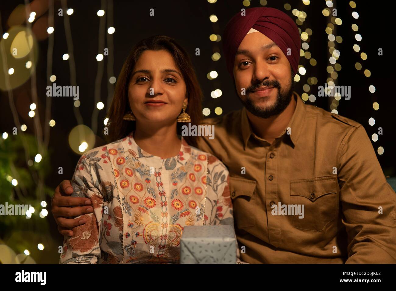 A SIKH MAN AND WOMAN POSING TOGETHER HAPPILY WITH GIFT IN HAND AND ...