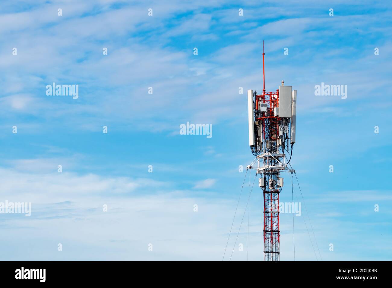 Telecommunication tower with blue sky and white clouds background. Antenna on blue sky. Radio ...