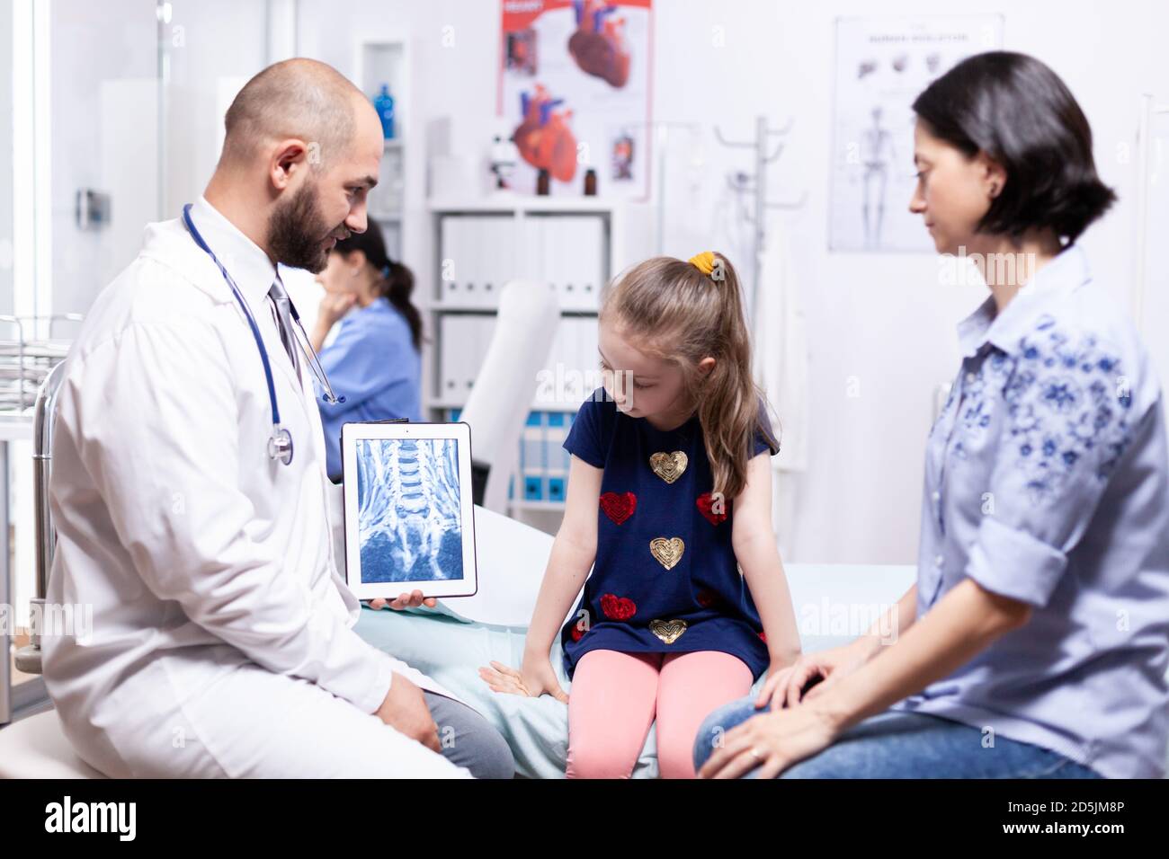 Pediatrician explaining radiography for sick child and mother in ...