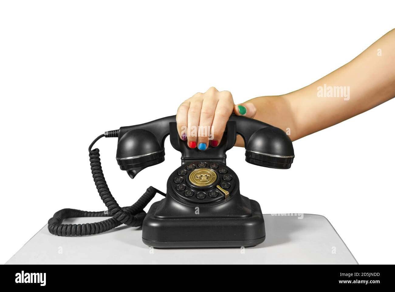 Hand holding the handset of an old black vintage rotary-style telephone ...