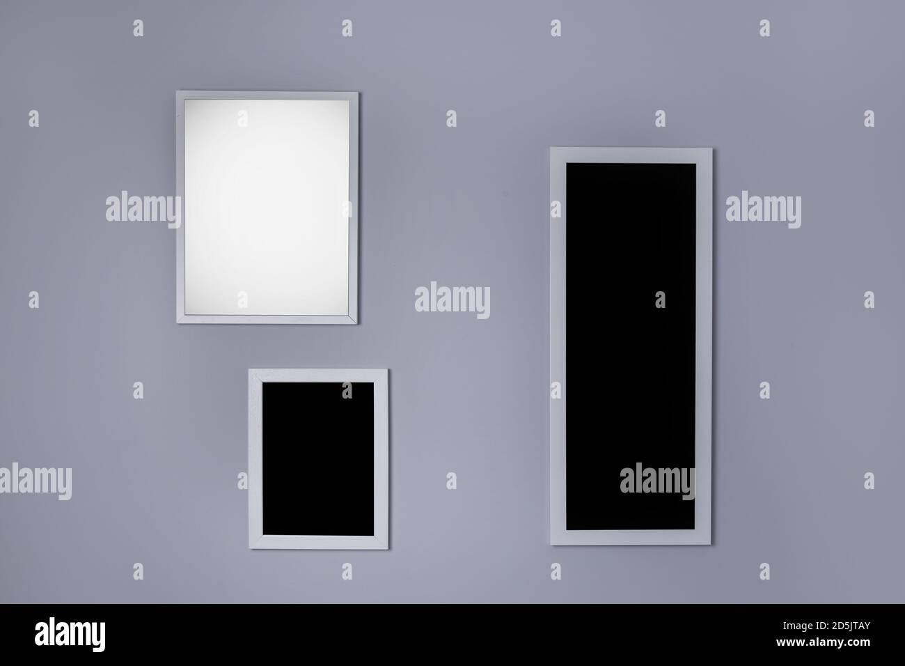 Poster mockup with three frames on empty grey wall Stock Photo - Alamy