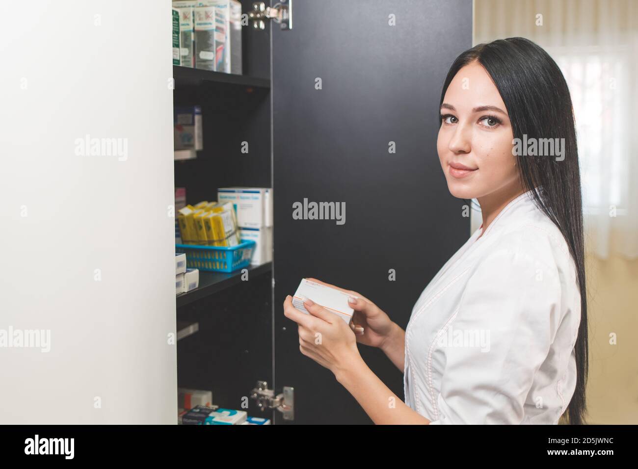 Pharmacy and medicine. A woman in a medical gown takes medicines from a ...