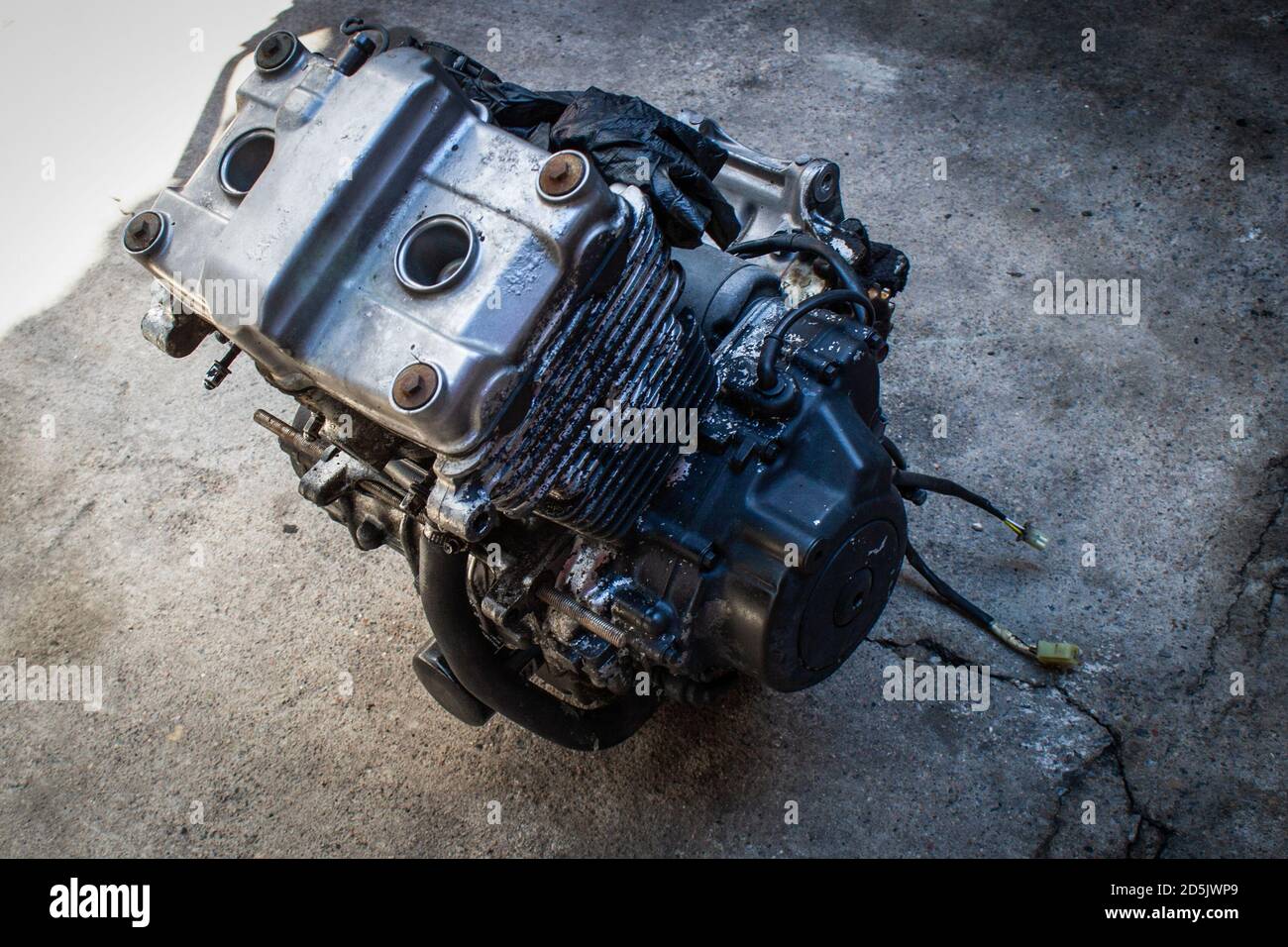 Old motorcycle engine isolated in a workshop, closeup. Motorbike broken ...