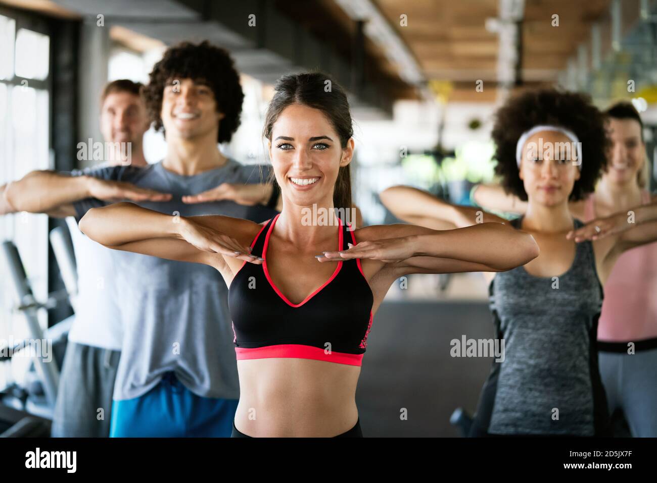 Beautiful fit people exercising together in gym Stock Photo - Alamy