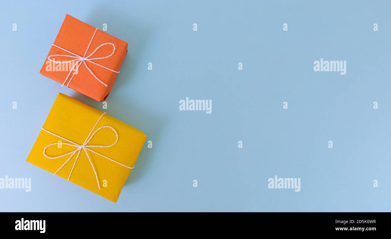 Yellow and orange gift boxes on a blue background. Simple flat lay with ...