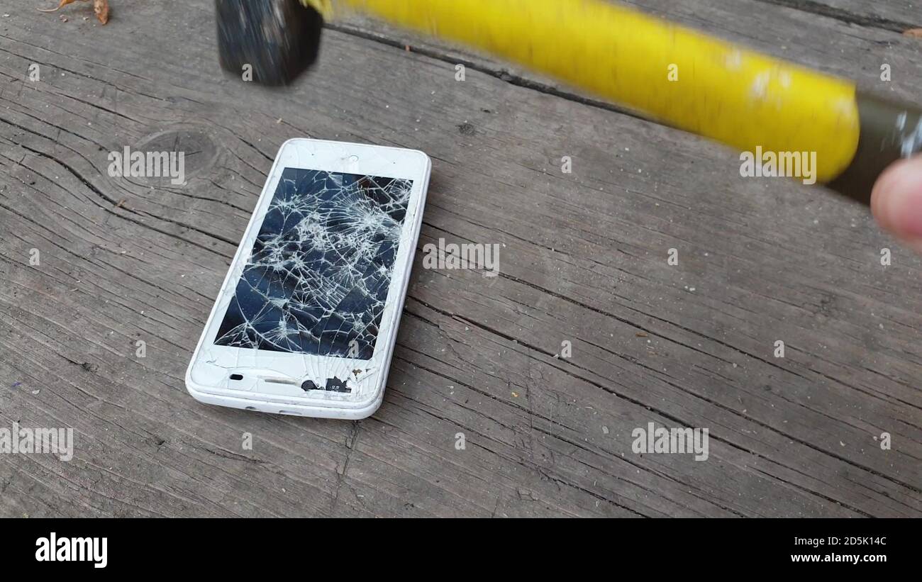 hammer smashes smartphone screen, recycling old and broken electronics ...