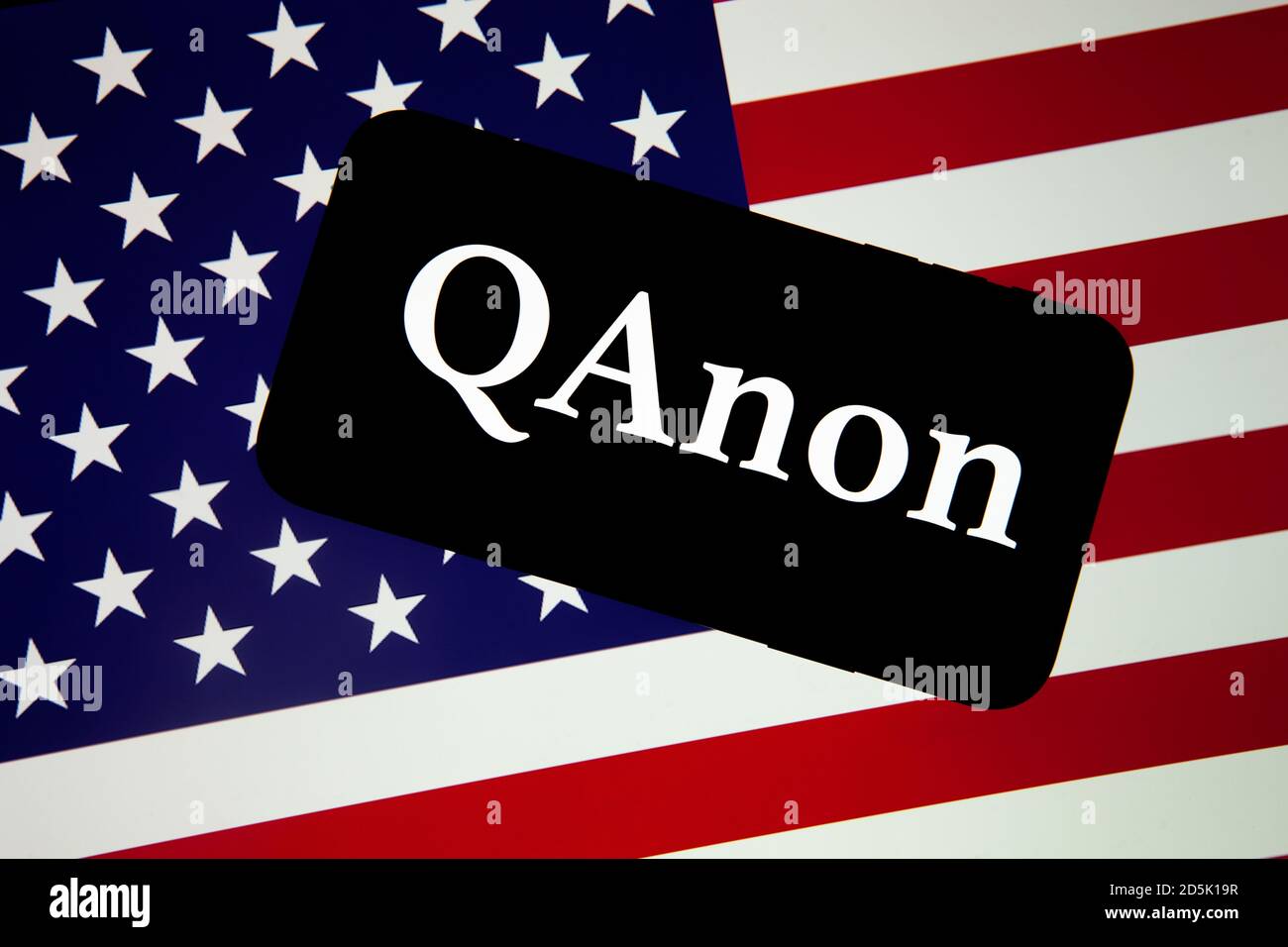 QAnon organisation logo seen on the smartphone which is placed on USA ...