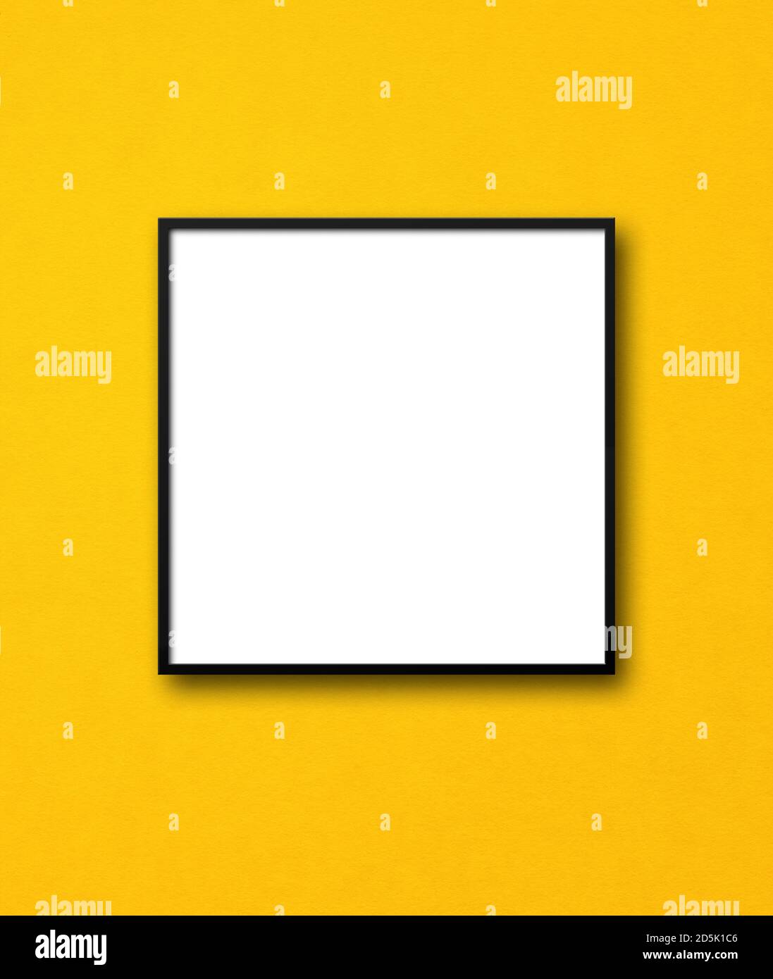 Black square picture frame hanging on a yellow wall. Blank mockup ...